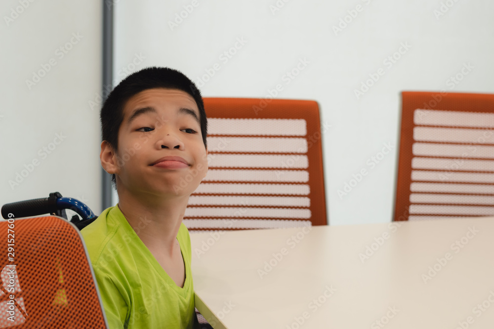 Asian special child on wheelchair smile happily, on the white table in ...