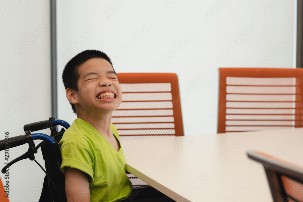 Asian special child on wheelchair smile happily, on the white table in ...