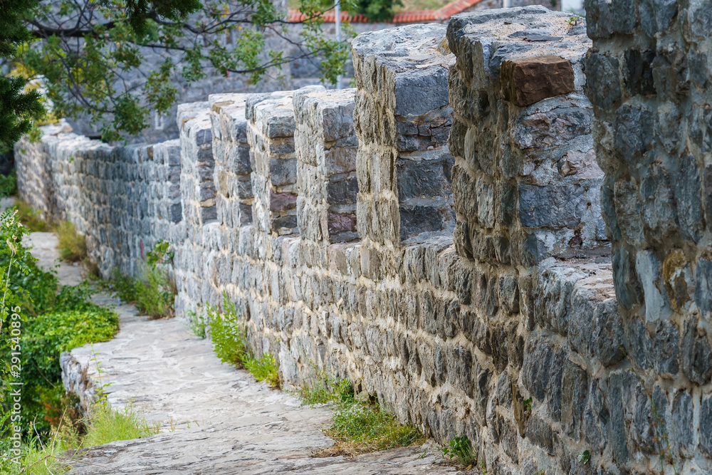 stone wall of a medieval fortress with openings for passage and ...