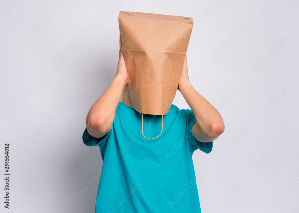 Fotka „Portrait of teen boy with paper bag over head covering ears with ...