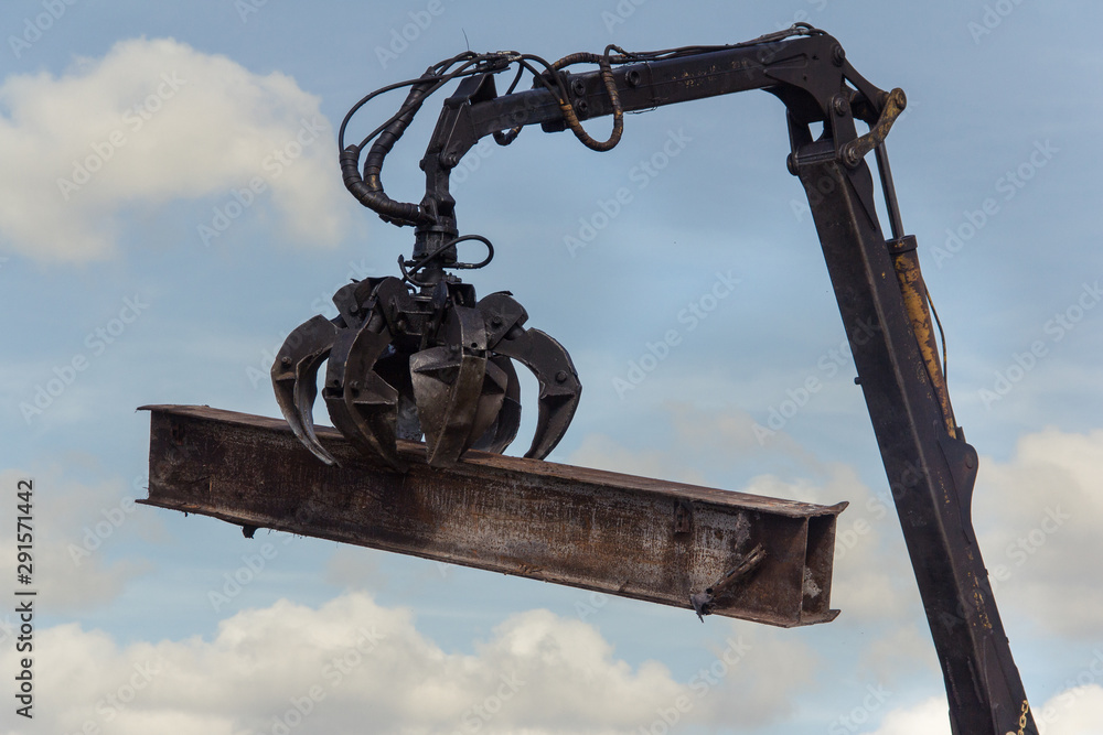 Mechanical grabbing arm manipulator on a background of blue sky. A ...