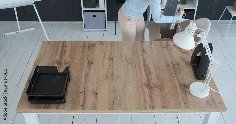 Businesswoman unpacking carton box and arranging her belongings on new ...
