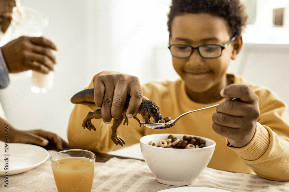 Boy do not eating flakes himself, but forcing a toy. Stock Photo ...