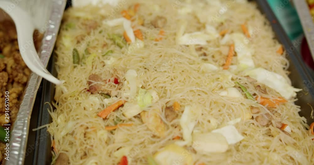 Gliding over the Filipino dish, pancit, and a tray of fried breaded ...