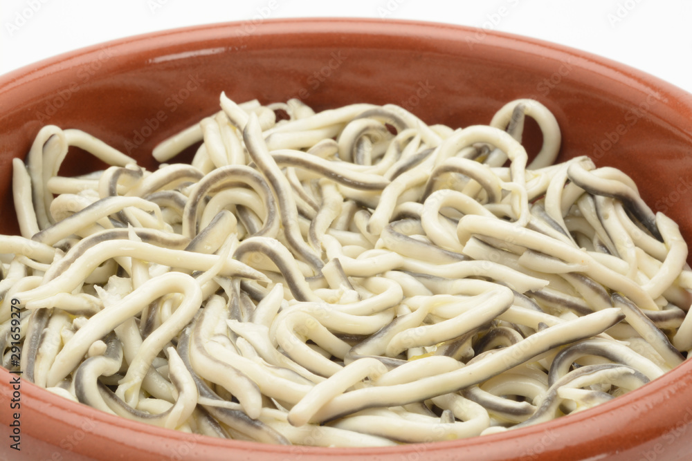 Gulas cocinadas en una cazuela de barro sobre fondo blanco, detalle ...