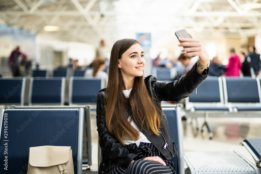 Foto de Beautiful young tourist girl in international airport, taking ...