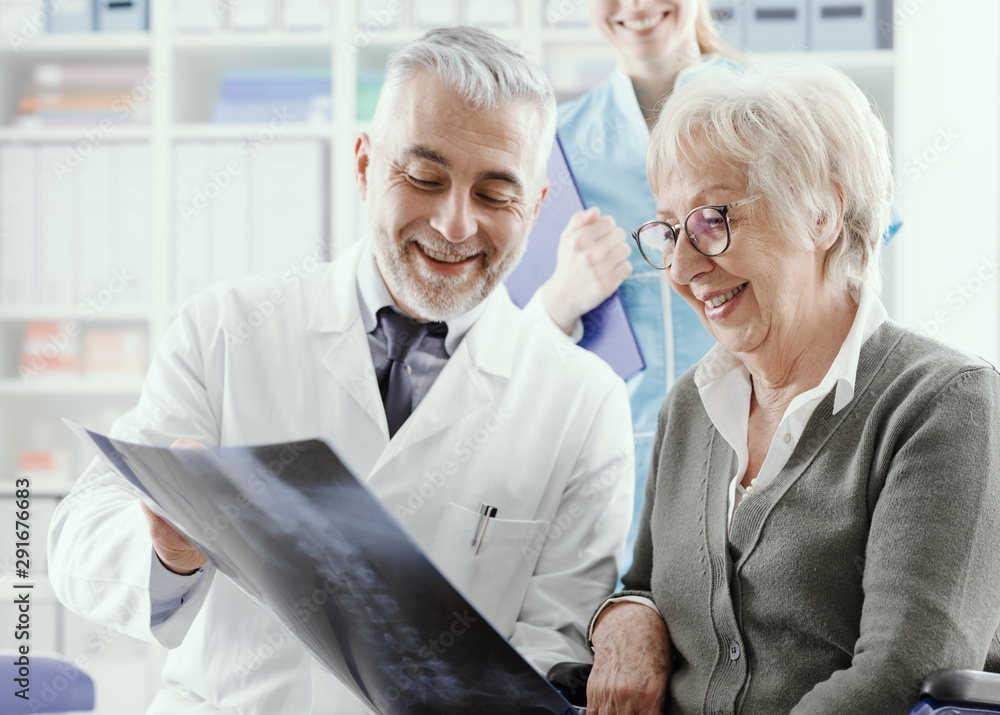 Radiologist checking an x-ray image with a senior patient Stock Photo ...
