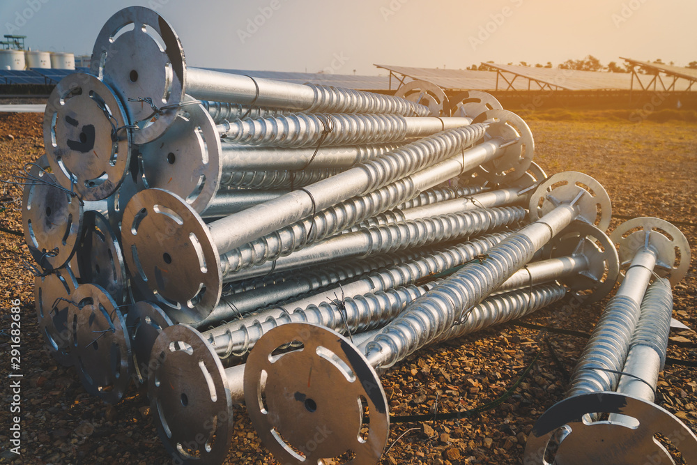 technician installing ground screw for mounting structure of solar ...