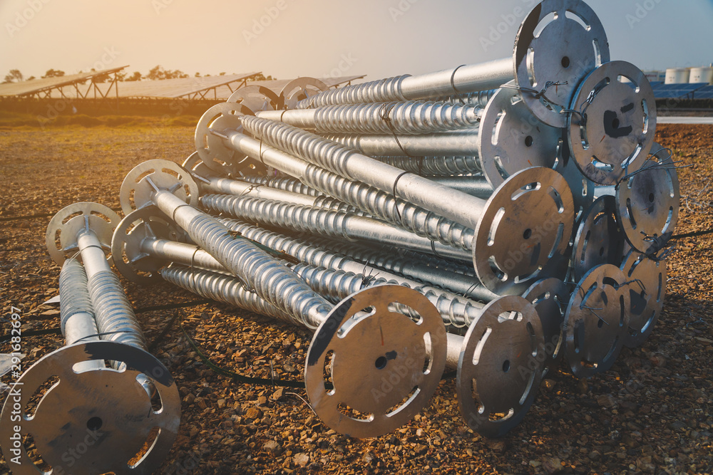 technician installing ground screw for mounting structure of solar ...