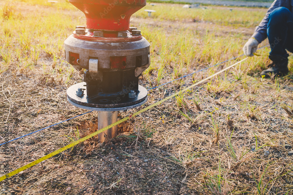 technician installing ground screw for mounting structure of solar ...