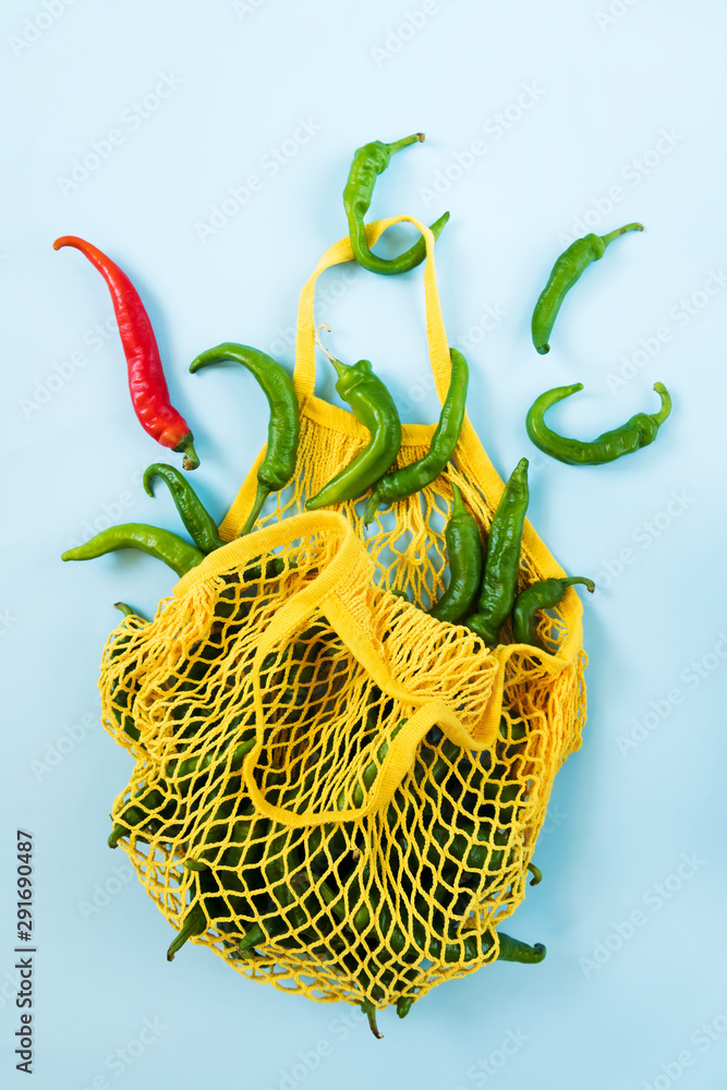 Creative layout green chilli peppers. Green vegetables in yellow string ...
