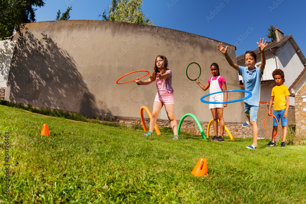 Kids throw hula hoops to target, competitive game Stock Photo | Adobe Stock