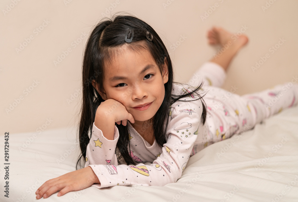 little girl lying on the bed and leaning on her arm Stock Photo | Adobe ...