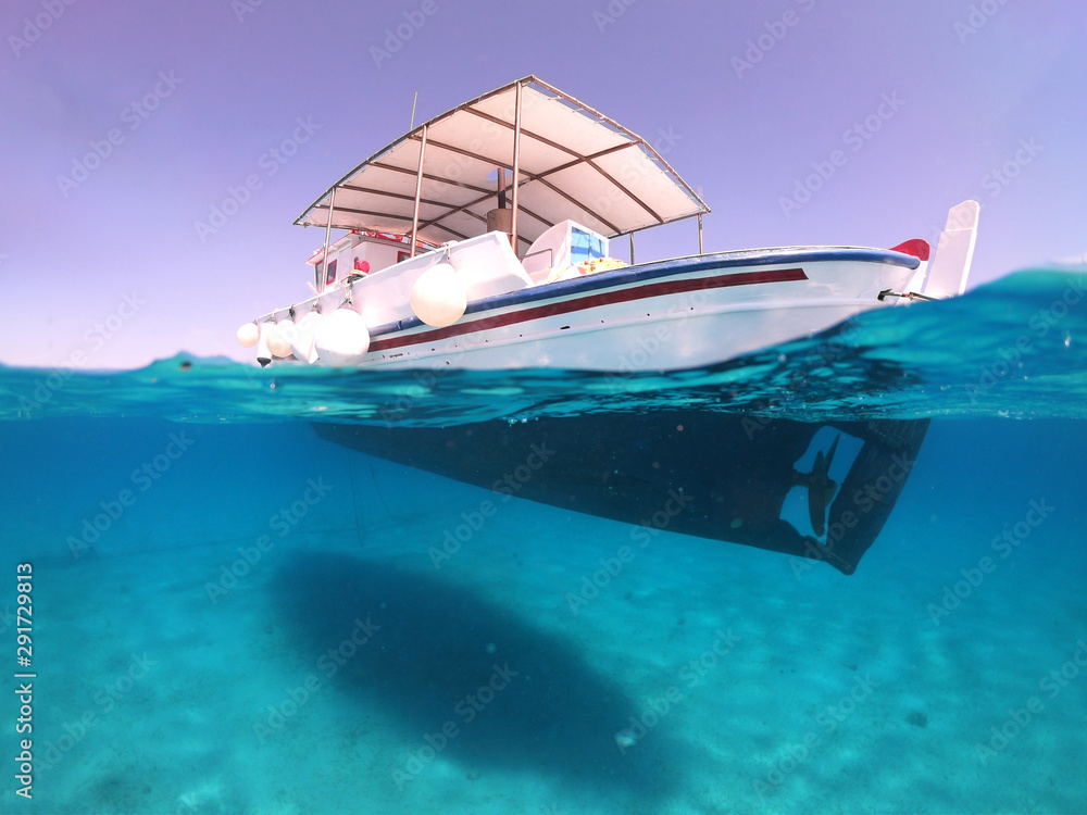 Above and below underwater photo of traditional fishing boat docked in ...