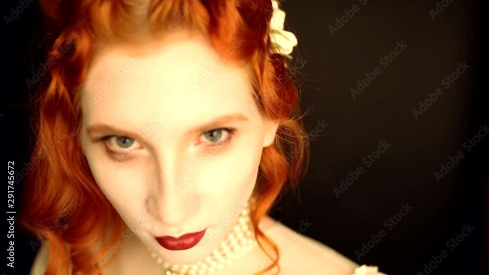 Young vampire woman with long curly hair, pale skin in a white dress on ...
