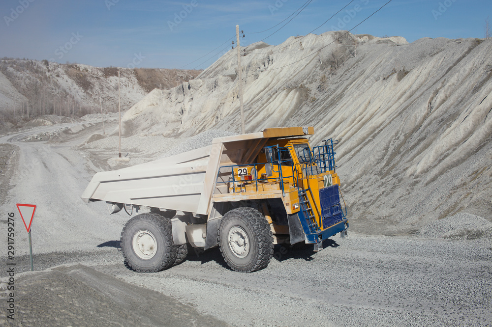 Heavy mining dump truck in a limestone quarry close-up. Mining industry ...
