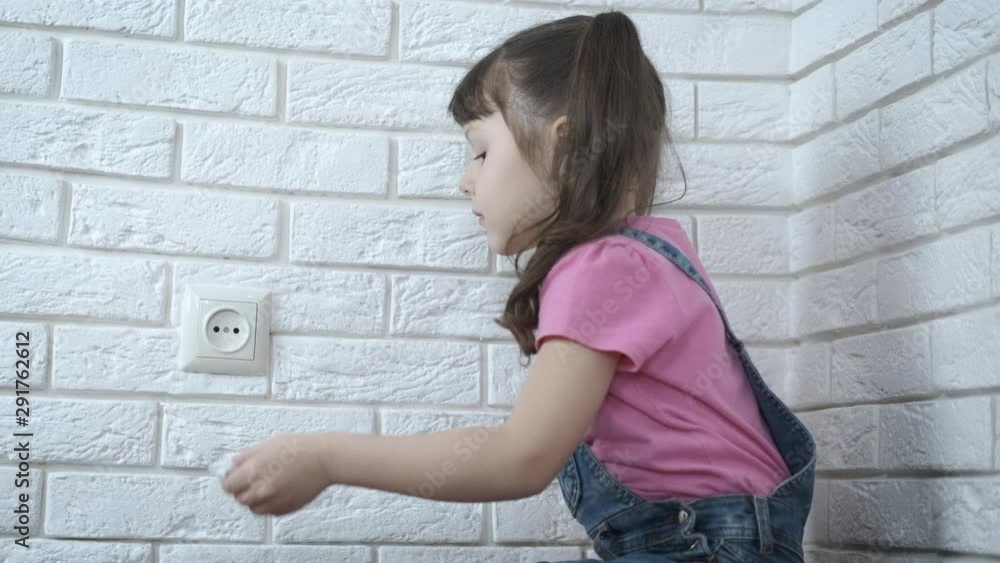 A kid with electricity. The little girl removes the protection from the ...