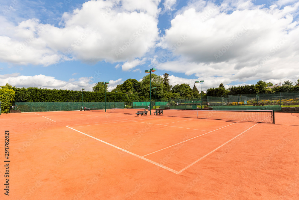 Empty tennis court with sports net and corner markings against sky ...