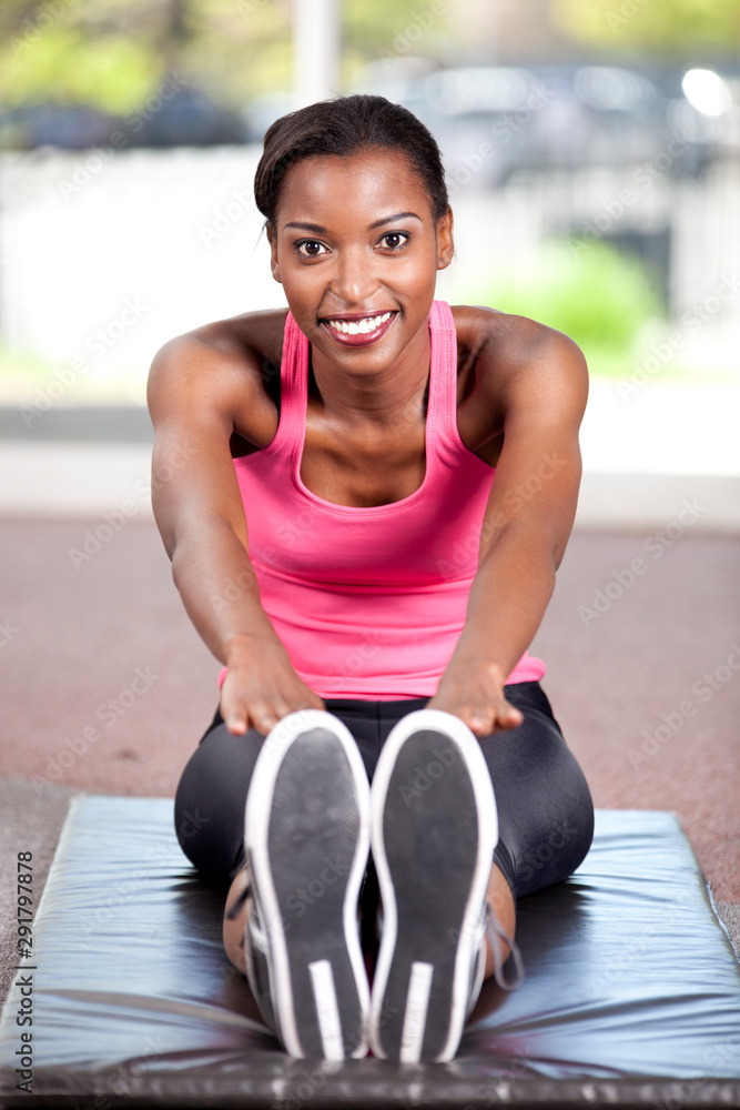 Young black female stretches in a gym Stock Photo | Adobe Stock