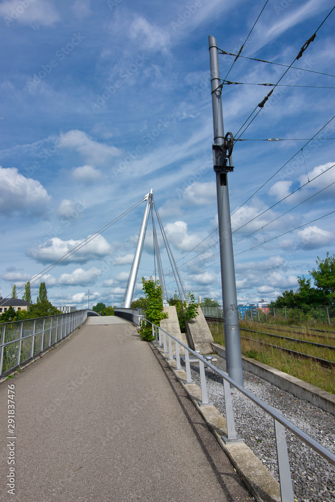 Bridge for pedestrians and tram, with railroad tracks and a pylon with ...