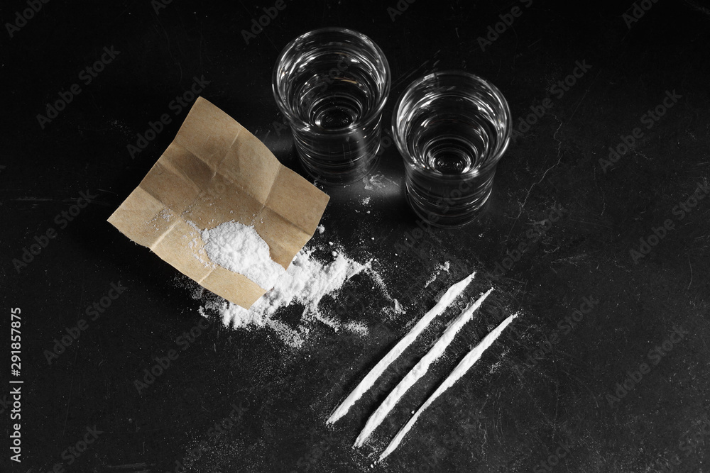 close up pile of cocaine in paper and vodka on black background, cocain ...