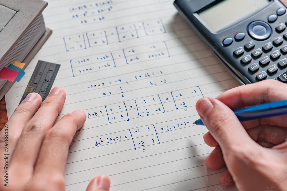 Foto de Solving math problem on paper do Stock | Adobe Stock