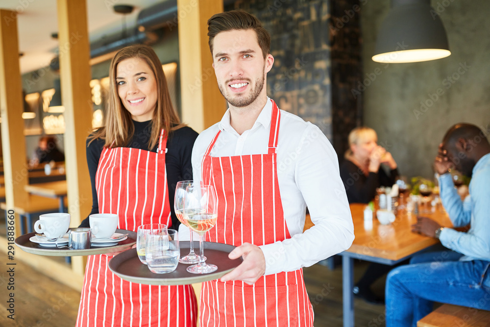 Kellner und Kellnerin beim Servieren im Bistro Stock Photo | Adobe Stock