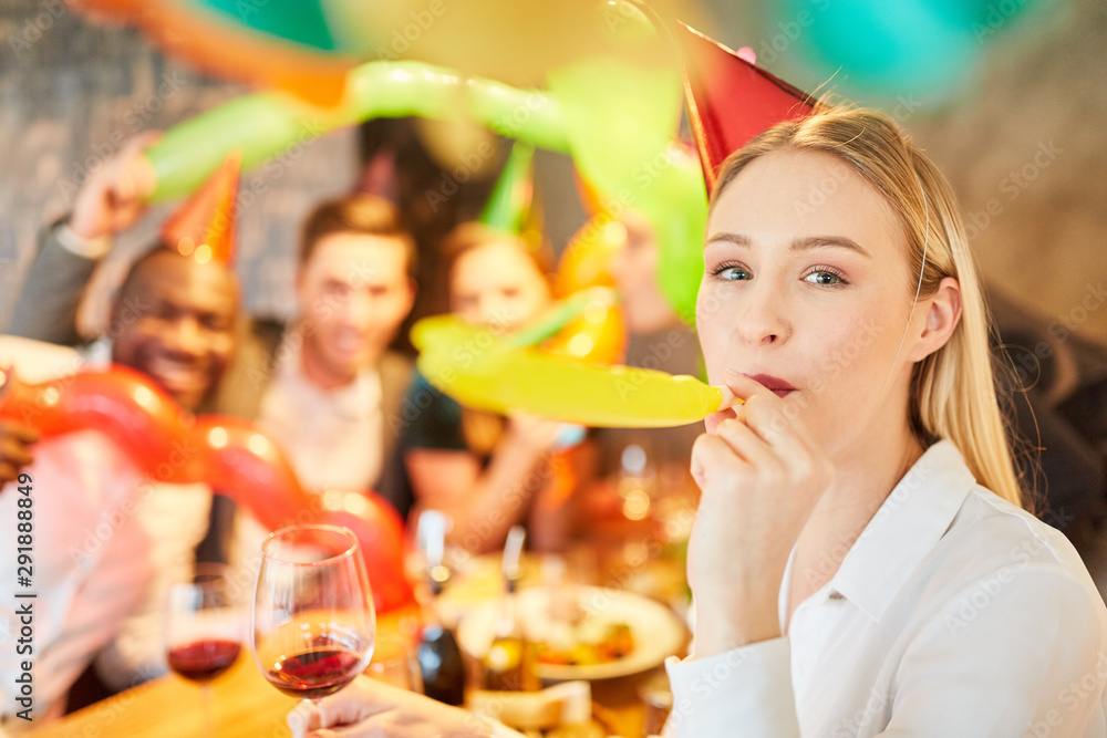 Frau auf einer Party im Karneval pustet in eine Tröte Stock Photo ...