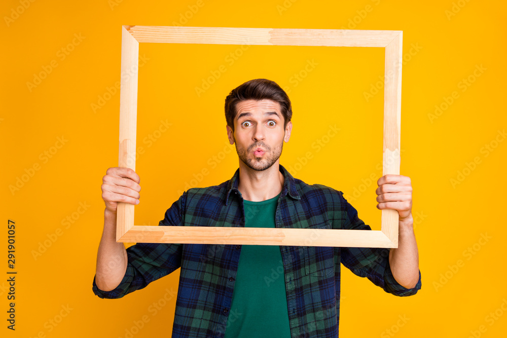 Photo of funny guy holding wooden picture frame looking through it ...