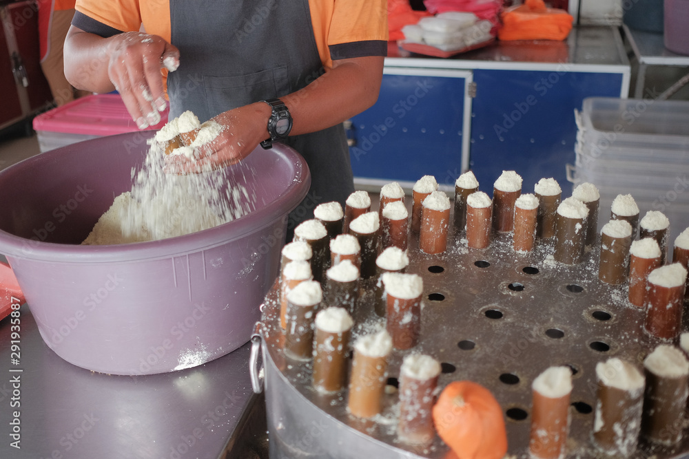 Steamer of traditional local green homemade dessert (Putu Bambu) with ...