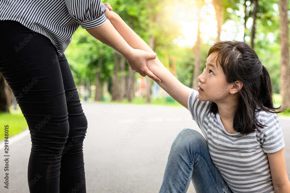 Passerby helping to support the child girl to stand up from on the ...