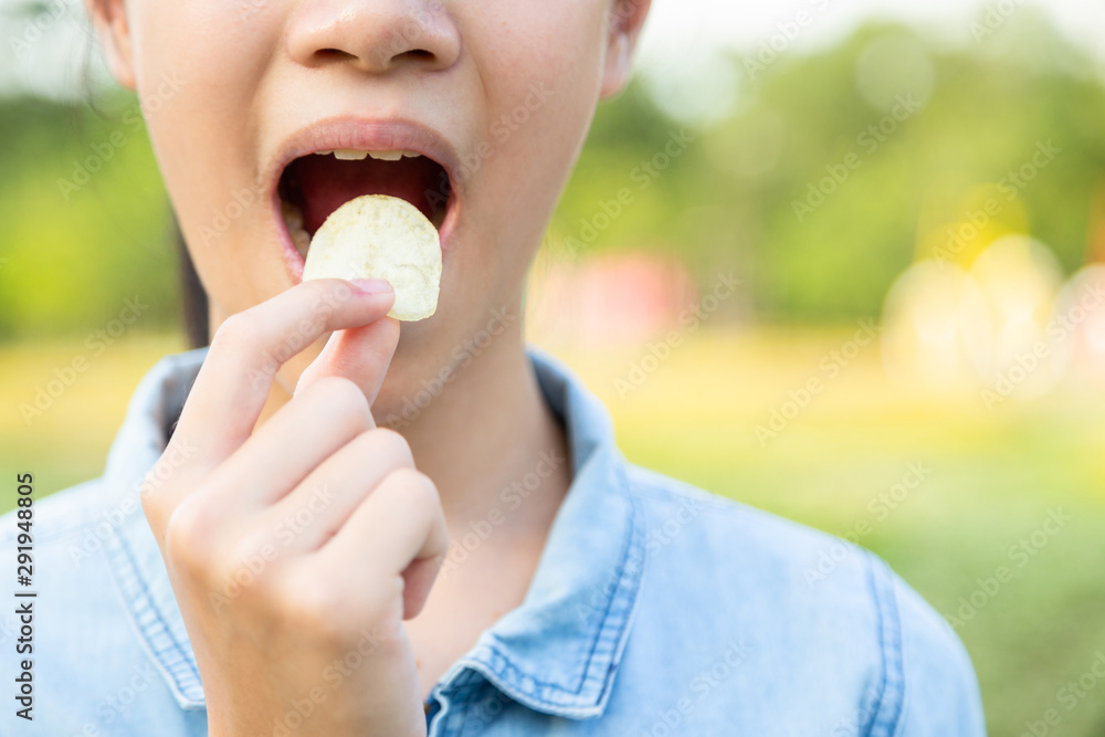 bad food,asian little child girl eating potato chips,young woman puts ...