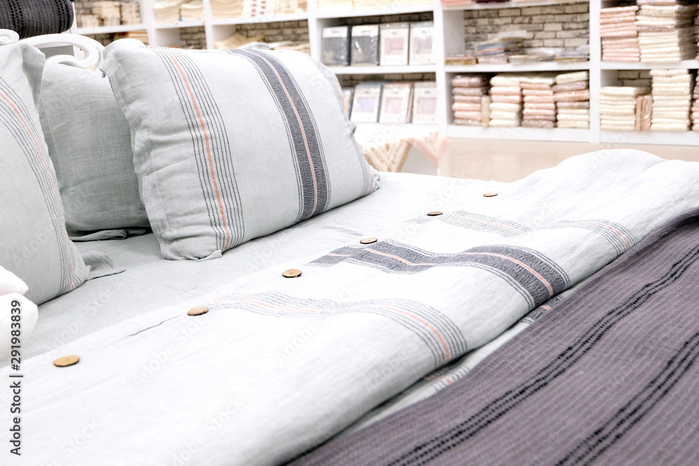 Bed linen on the bed in the textile store. Interior view of the trading ...
