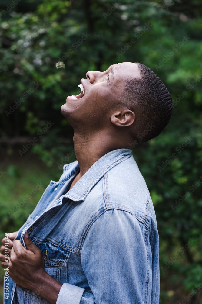Young man crying and holding fist over heart Stock Photo | Adobe Stock