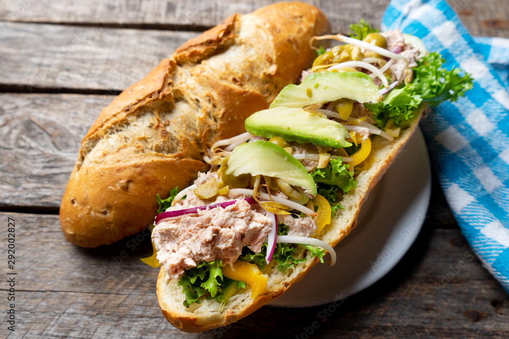 Tuna sub sandwich in rustic baguette with avocado, olives and sprouts ...