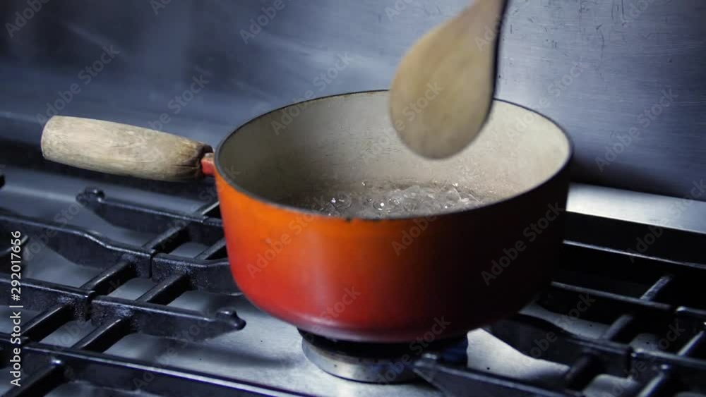 Slow motion - Chef stiring pan of boiling water on stainless steel ...