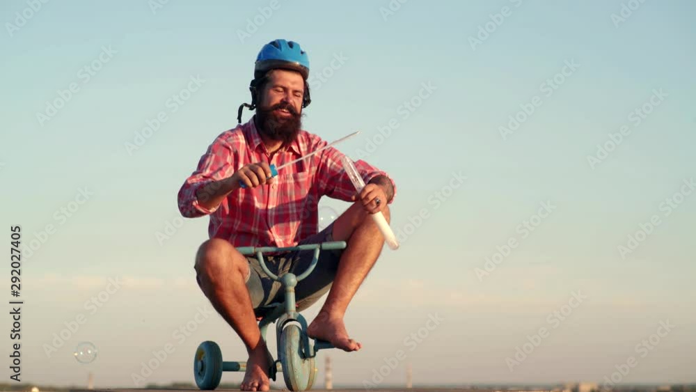 Crazy funny man rides a bike on sky background. Funny man with child ...