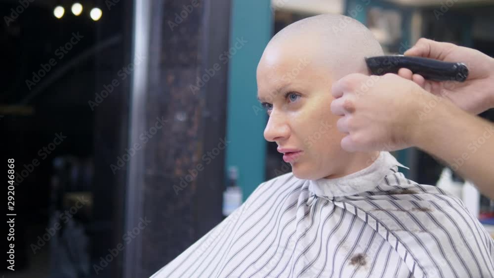 concept of hair loss after chemotherapy. the hairdresser shaves the ...