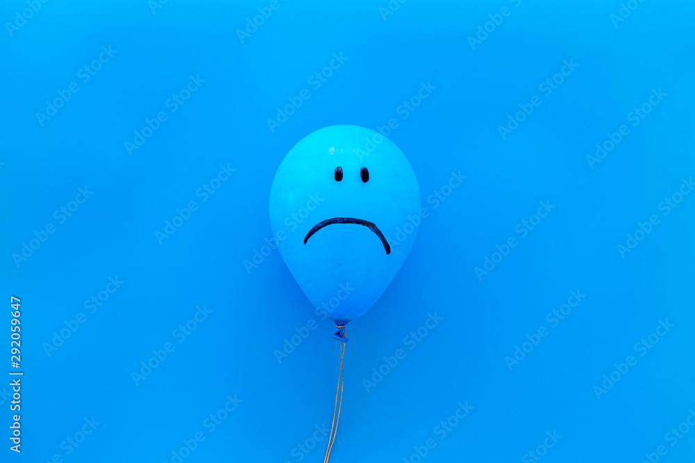 Treat depression concept. Balloon with sad face on blue background top ...