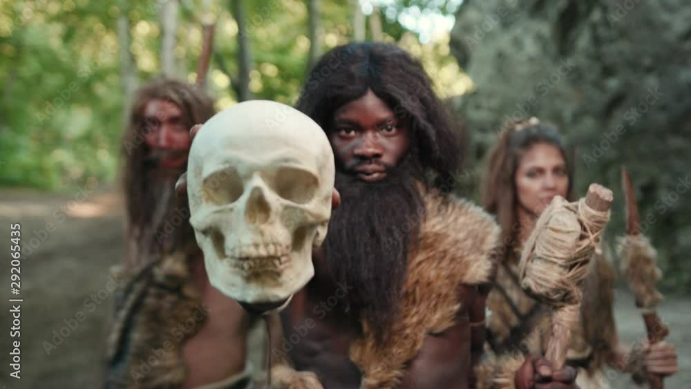 Savage tribe of primitive hunter-gatherers showing human skull at ...