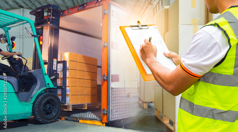 Worker Holds a Clipboard Controlling the Loading of Packaging Boxes ...