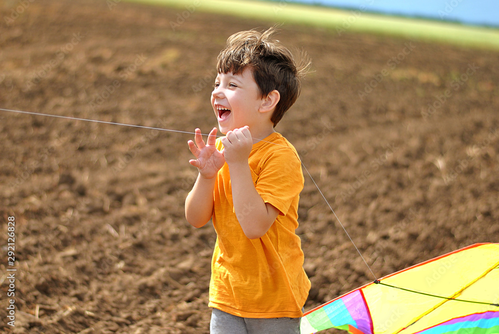 Laughing smiling little boy child enjoys kite launching. Happy kid with ...