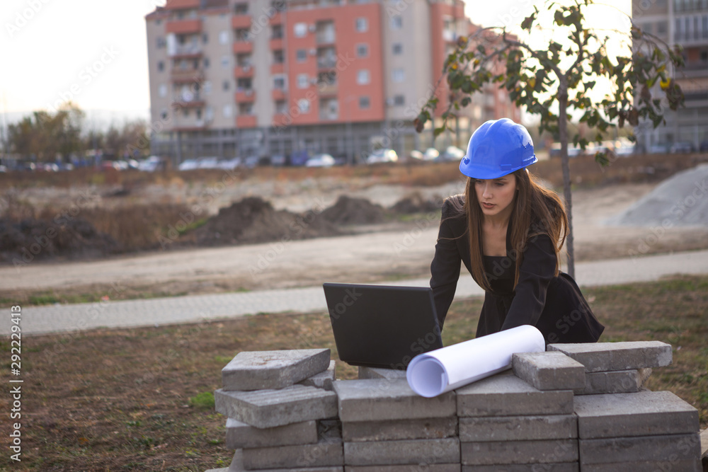 A beautiful young woman landscape architect is looking at a ...