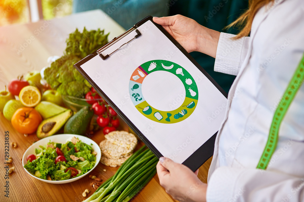 Holding schematic meal plan for diet with various healthy products on ...