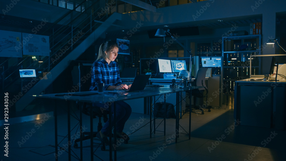 Beautiful Female Engineer Sitting at Her Desk Works on a Laptop ...