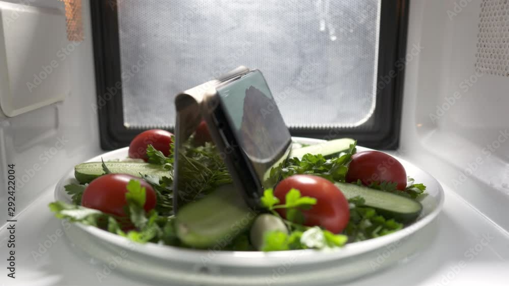 Cellphone with whole roasted chicken baked in oven on screen in ...