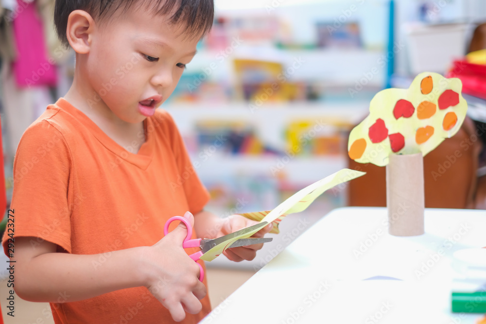 Cute Asian boy cutting a piece of paper, Introduce scissor skills for ...