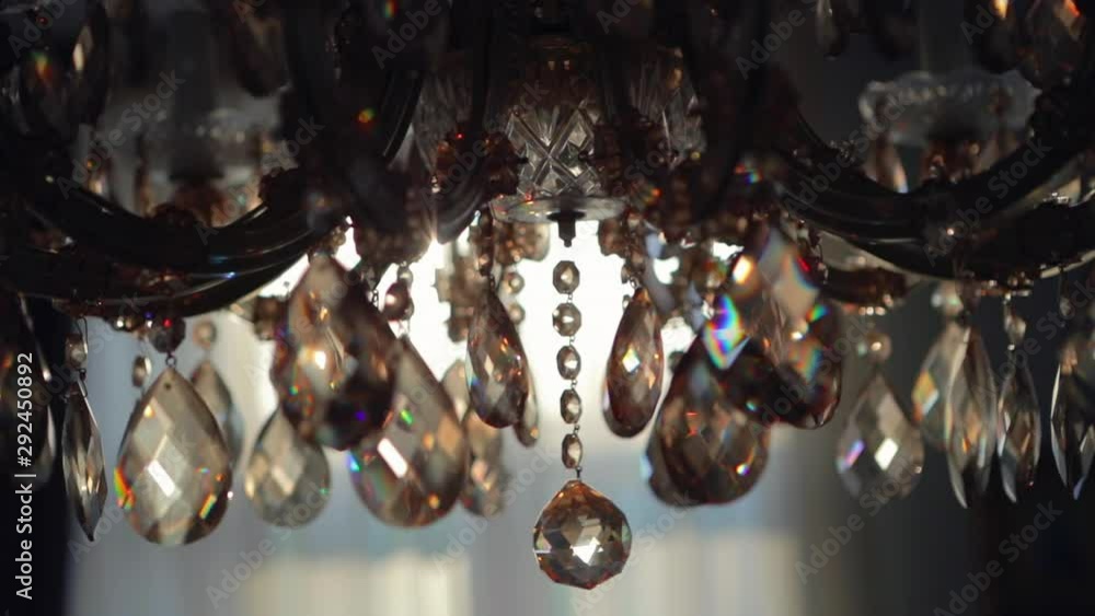 Abstract close-up pan across glass in crystal chandelier with sparkling ...
