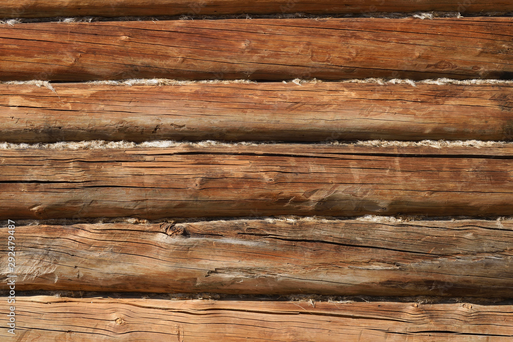 Cracked brown log wall of an old wooden blockhouse with oakum in ...