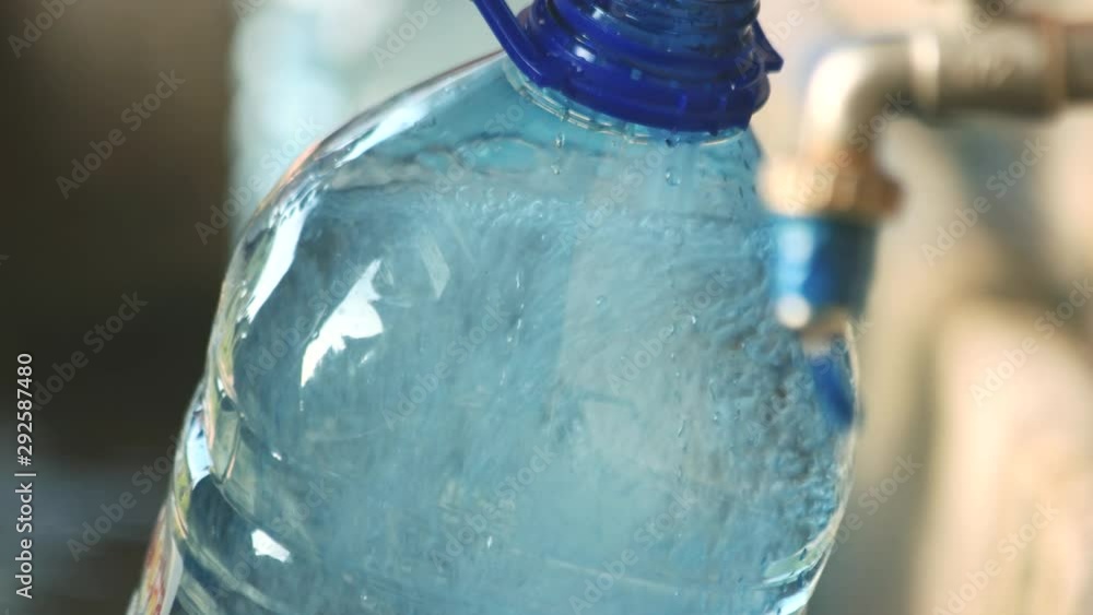 Filling plastic bottle with clean drinking water. Purified water ...